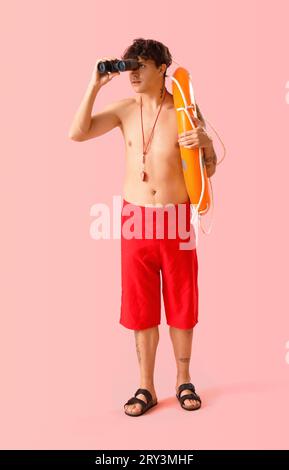 Male lifeguard with binoculars and ring buoy on blue background Stock ...