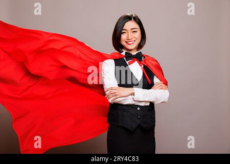 Asian receptionist posing with red superhero cape on camera, feeling ...