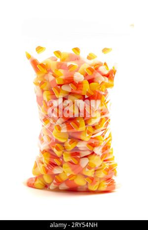 Halloween treat bag filled with candy corn candies on white background ...
