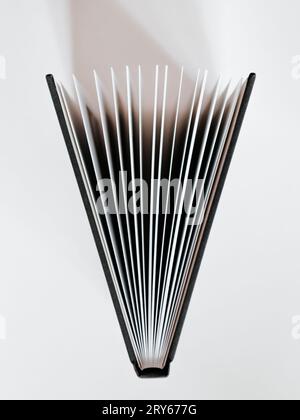 An open book on a white table and a bottle of coffee grains, the ...