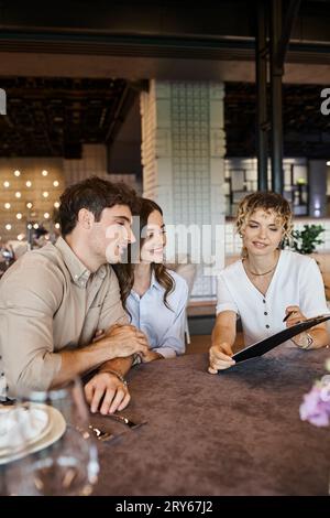 event coordinator showing clipboard with contract to happy couple in ...