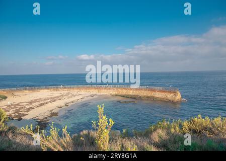 curved ocean pier with waves Stock Photo - Alamy