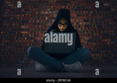 Hacker, woman in basement and laptop, coding and IT with code overlay ...