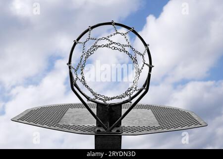 Metallic basketball board and hoop with blue sky and white clouds at ...