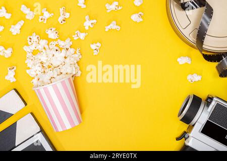 Movie clapper with bucket of popcorn, film reel and Santa hat on beige ...