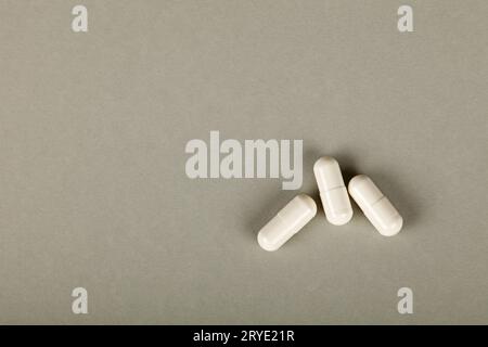 Close up three gel cap pills over grey background Stock Photo - Alamy