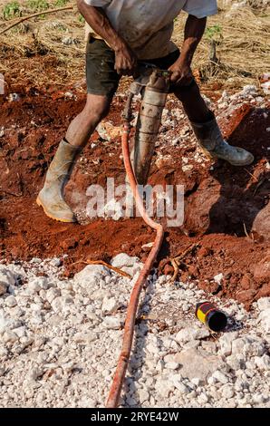 Heavy machine with demolition jackhammer is breaking asphalt on a city ...