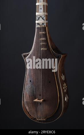 part ancient Asian stringed musical instrument on black background with ...