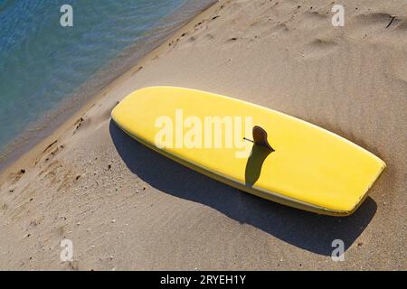 Close up one yellow surfing board on sand sea beach, high angle view ...