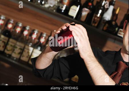 a barkeeper or bartender mixing drinks together in a bar barkeeper ...