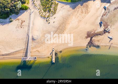 Aerial view of a T shaped jetty on the edge of a sandy beach at Barwon ...