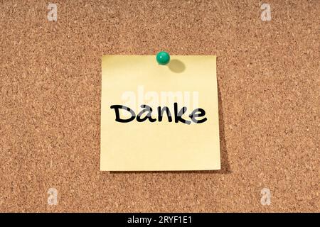 Thanks word in german language on yellow note on cork board Stock Photo ...