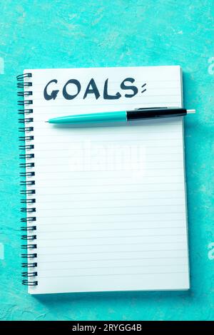 Goal setting. A notebook with the handwritten word Goals, with a cup of ...