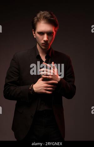 elegant brutal man in formal wear has groomed hair drinking whiskey ...