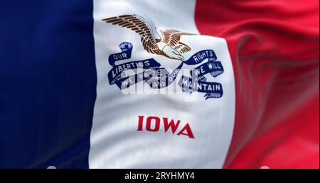 Detail of the Iowa state flag waving. Three vertical stripes of blue ...