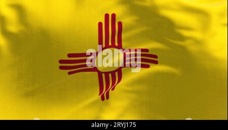 Close-up of New Mexico state flag waving in the wind. Symbol of Zia red ...