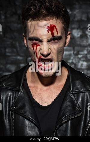 Zombie man screaming in darkness with makeup for halloween party Stock ...