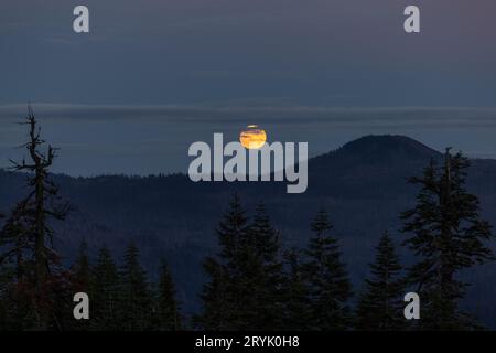 Close up of the harvest supermoon rising over the cascade mountains in ...