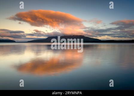 Suns last rays on Mt Tarawera with boat jetty in foreground. Sunset ...