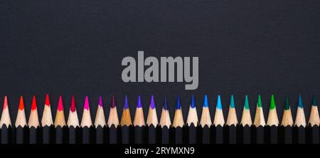 Creative minimal banner. Colored pencil set arranged in line on black ...
