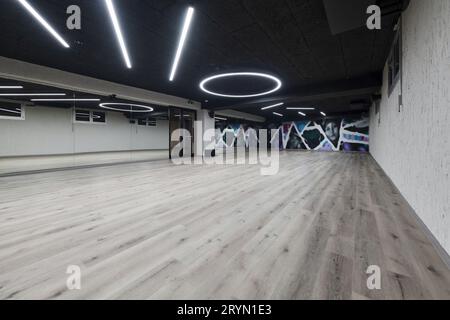 An empty dance hall with a glass wall adorned with decorative graffiti ...