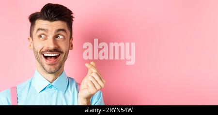 Valentines day concept. Romantic guy showing finger heart and looking ...