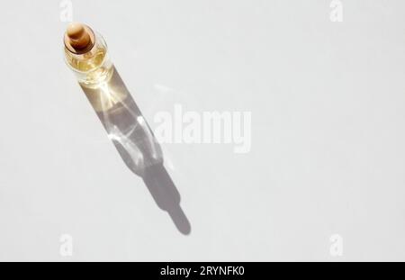 Serum with collagen and peptides in transparent glass bottle on light ...