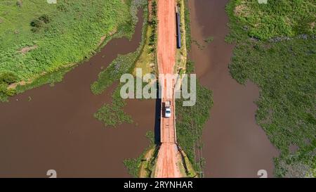 Close-up aerial view of a Pick up truck crossing a bridge over a lagoon ...