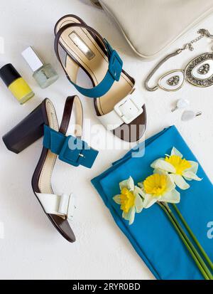 flat lay with womens accessories, cosmetics and perfume on vhite shirt ...