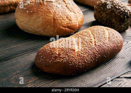 Loaves of different bread on wooden background Stock Photo - Alamy
