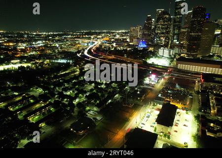 An aerial view of the vibrant Houston skyline at night with illuminated buildings across the ...