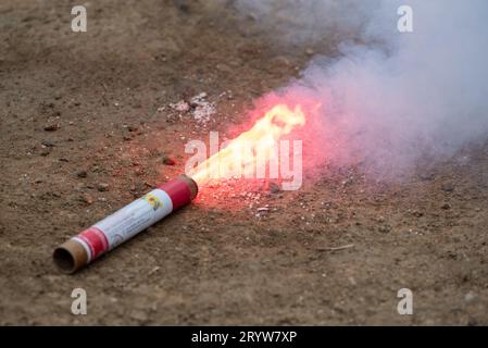 Burning signal flare blazing on the ground. Fire and smoke Stock Photo ...