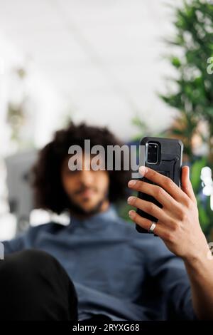 selective focus arab man chatting at smartphone after shopping with his ...