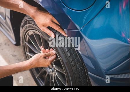 Closeup male automotive technician removing tire valve nitrogen cap for ...