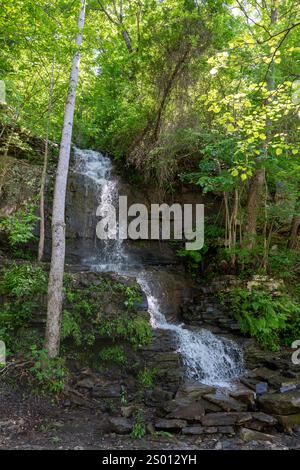 A small waterfall surrounded by big rocks Stock Photo - Alamy