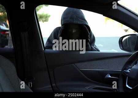 Thief looking into car through side window Stock Photo - Alamy
