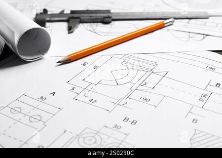 Different engineering drawings, vernier caliper, pencil and glasses on ...