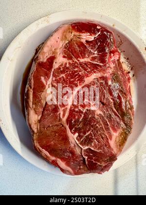 Large raw, marbled beef chuck roast ready for seasoning before being ...