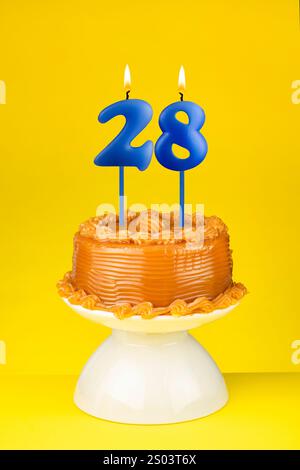 Candle number 28 - Vanilla cake in orange background Stock Photo - Alamy