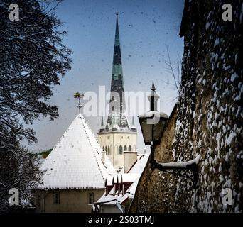 A snow-covered scene featuring a historic church tower with a ...