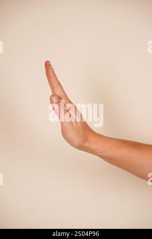 With the palm open and facing outward, the hand gestures a stop or ...