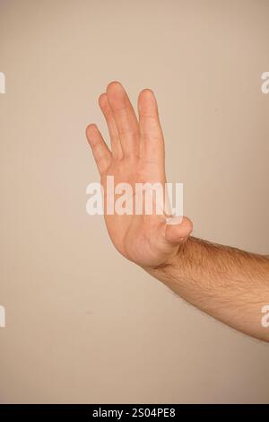 With the palm open and facing outward, the hand gestures a stop or ...