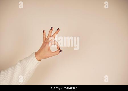 The thumb and index finger form a loop, with the other fingers raised ...