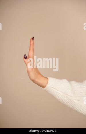 With the palm open and facing outward, the hand gestures a stop or ...