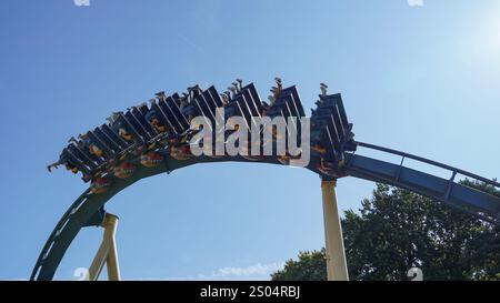 People ride through an inversion on the intense inverted roller coaster ...