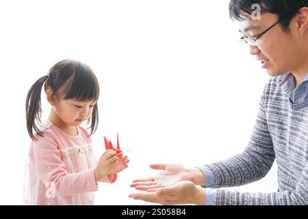 Child and father doing Origami Stock Photo - Alamy