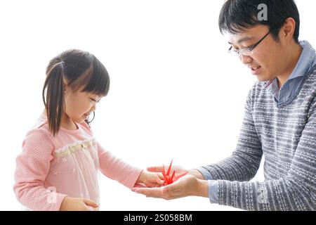 Father and child girl doing origami crafts together. Modern parenthood ...