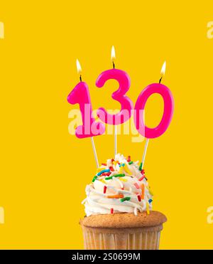 Pink number 130 birthday candle lit on white background Stock Photo - Alamy