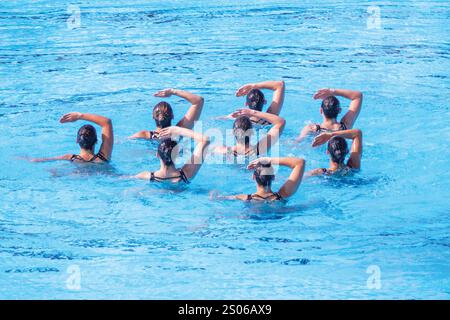 Artistic swimmers team performing synchronized choreographed routine in ...
