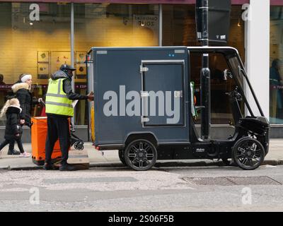 A driver unloading parcels from an Amazon Mubea electric cargo bike on ...